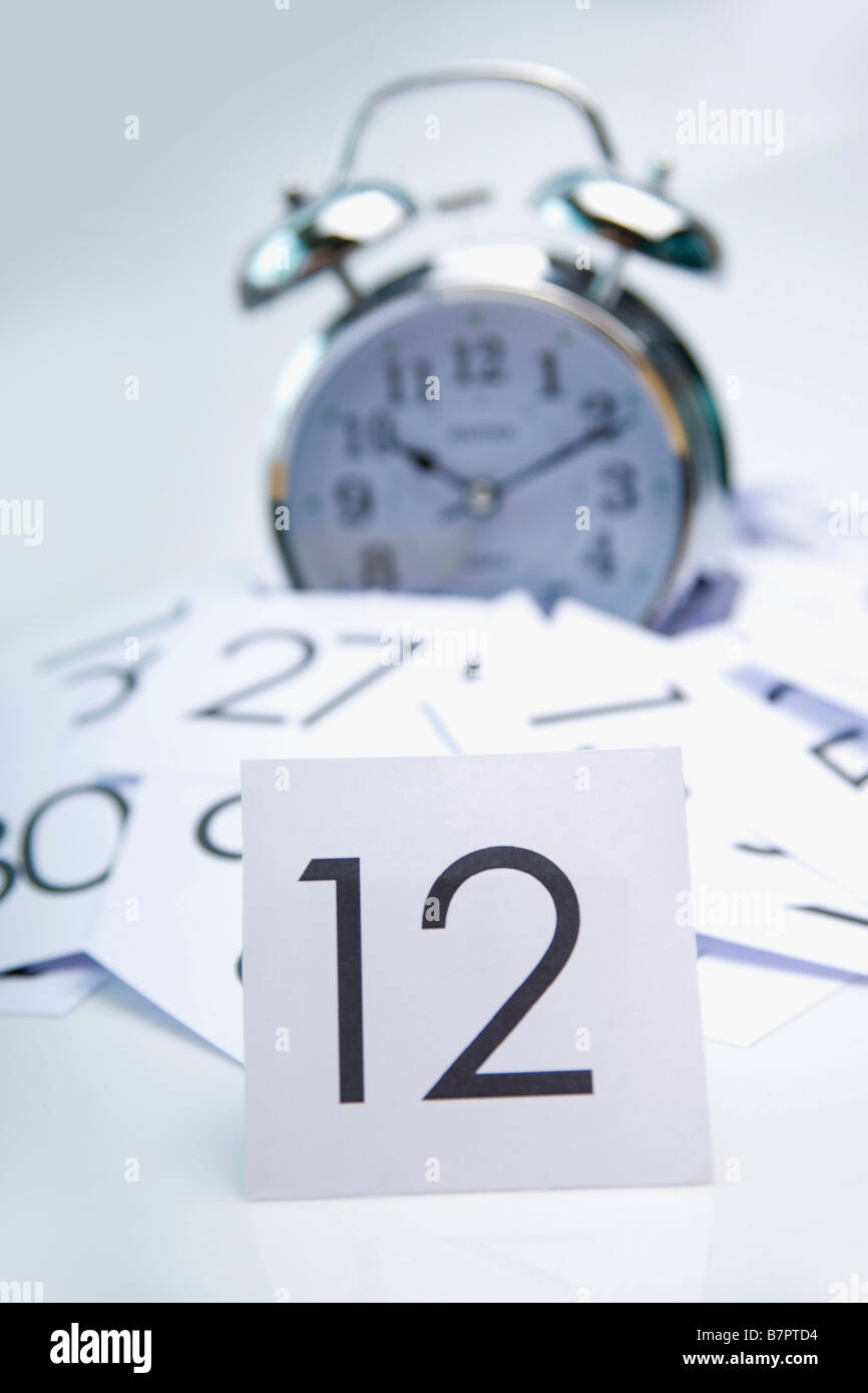 Alarm clock on stack of papers Stock Photo - Alamy