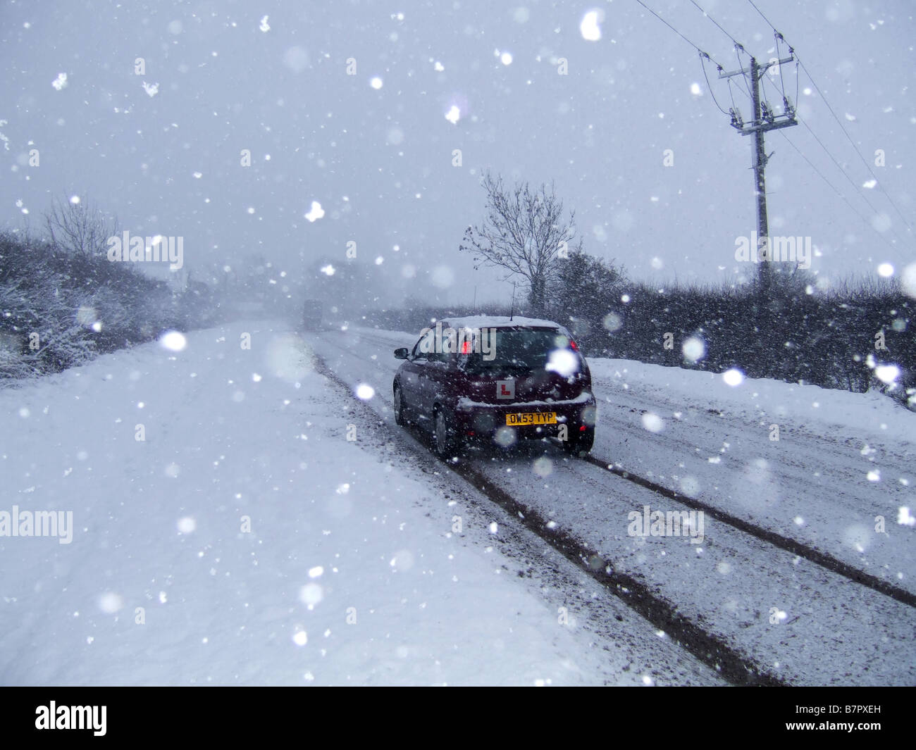 Learner driver in a vauxhall corsa car driving along a snow covered ...