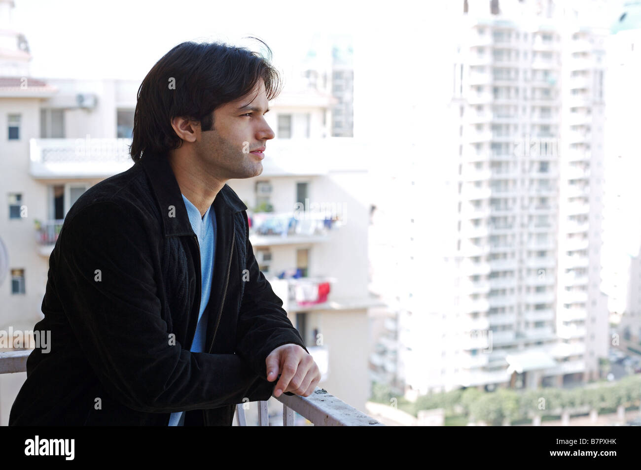 Side view of a man standing in balcony Stock Photo - Alamy