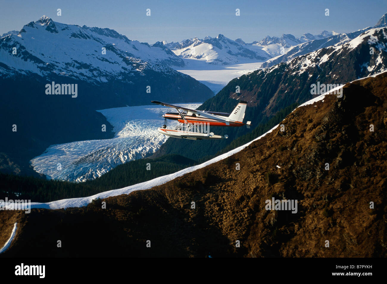 Helio-Courier floatplane flying over Mendenhall Valley w/Glacier ...