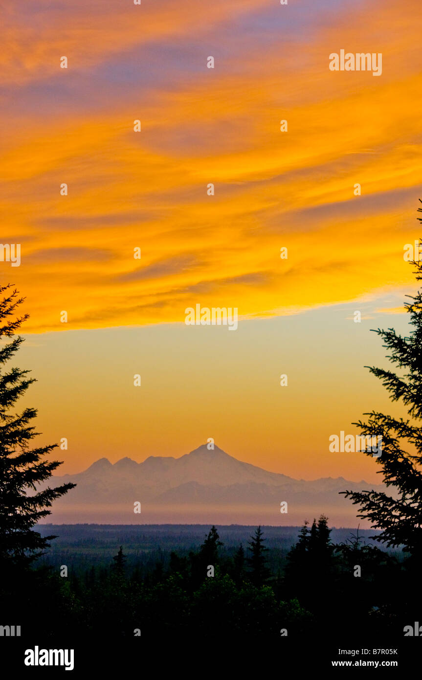 Sunset clouds blaze orange over Iliamna Volcano as seen from the hills ...