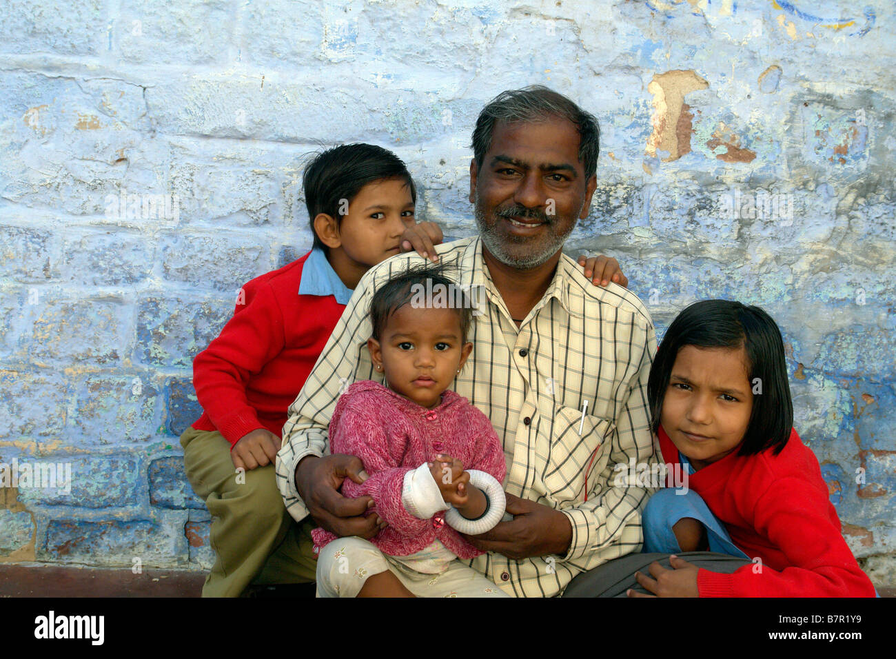 indian father and his three children in the back streets of the old ...
