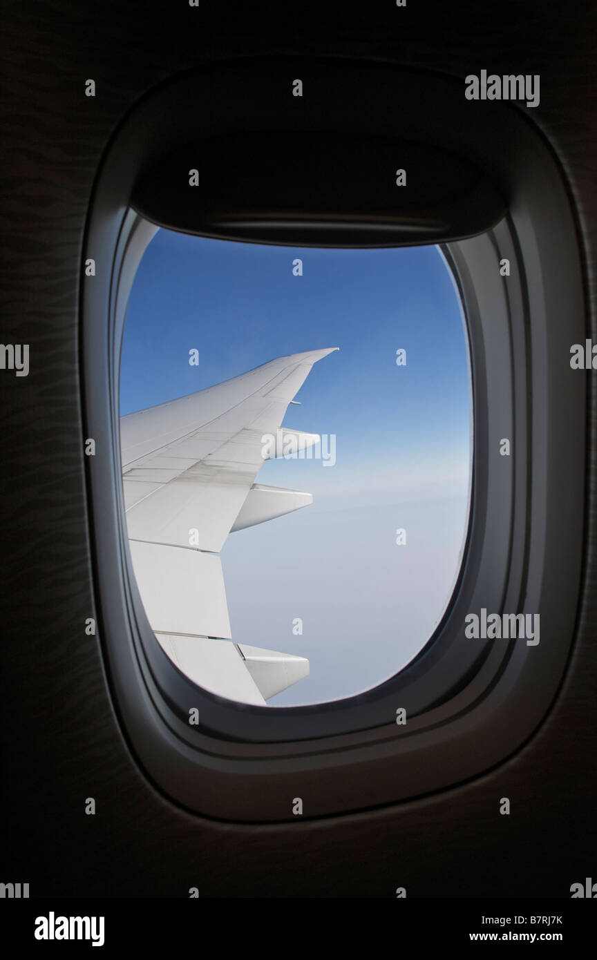 Aeroplane wing against blue sky through cabin window Stock Photo - Alamy