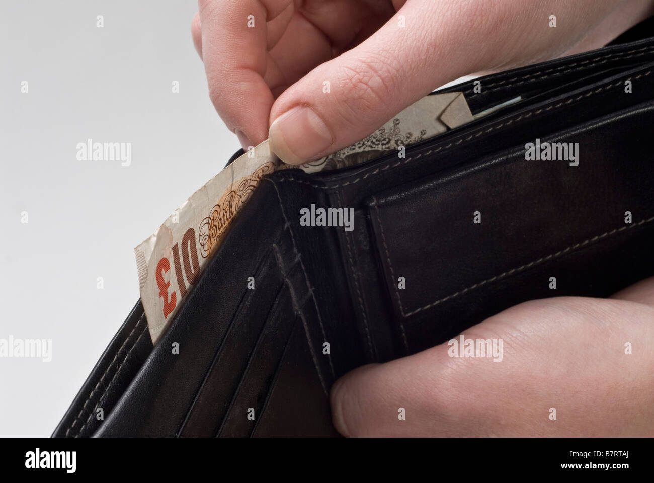 Taking a ten pound note from a wallet Stock Photo - Alamy