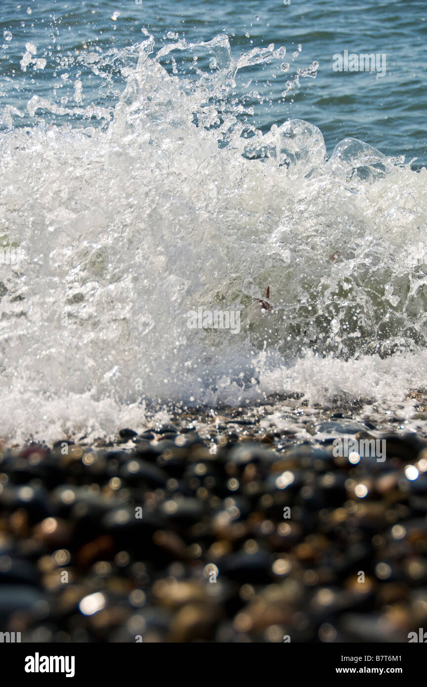 Waves crashing onto shingle beach Stock Photo - Alamy