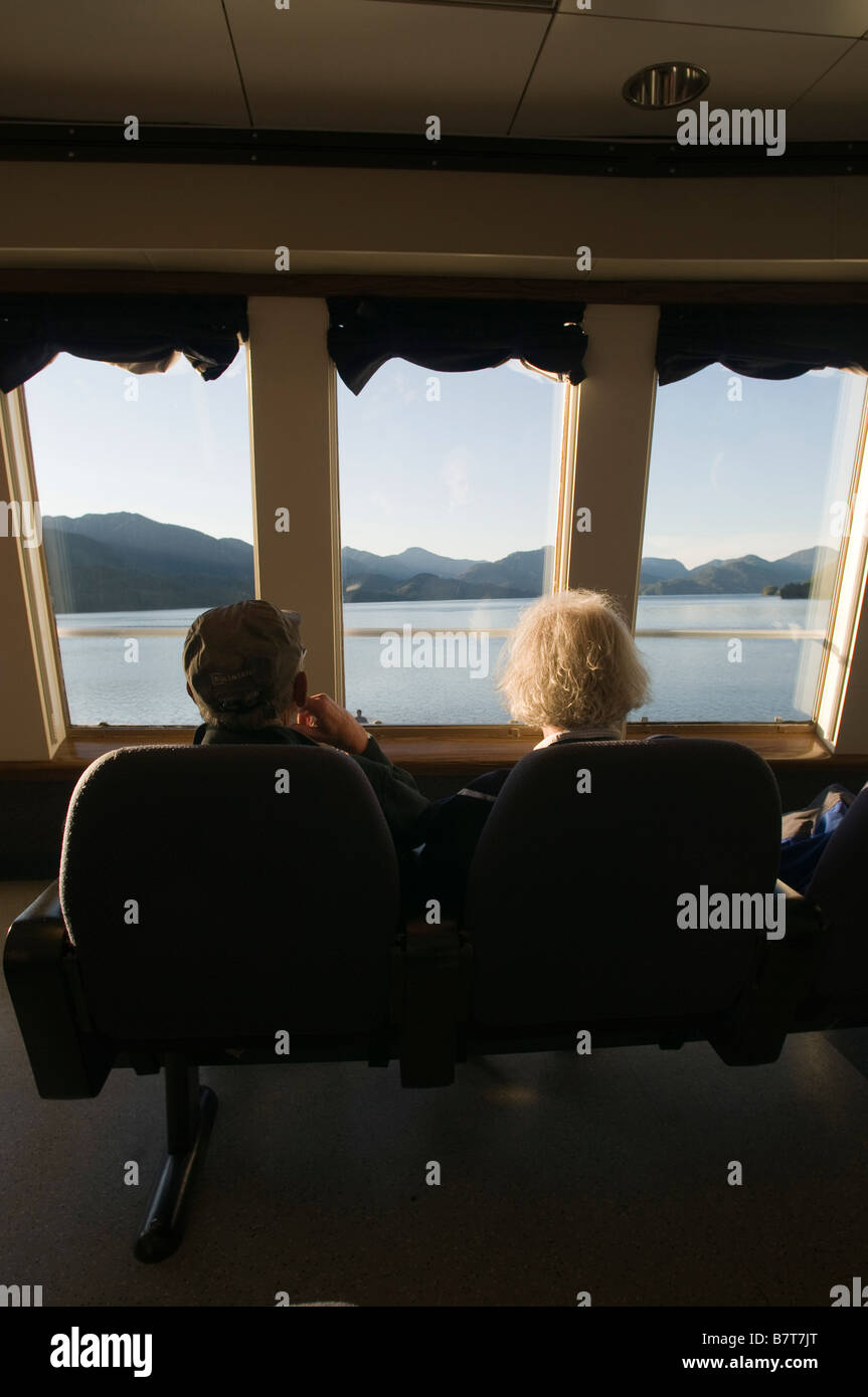 Tourists looking out the window of the observation deck of the Alaska ...