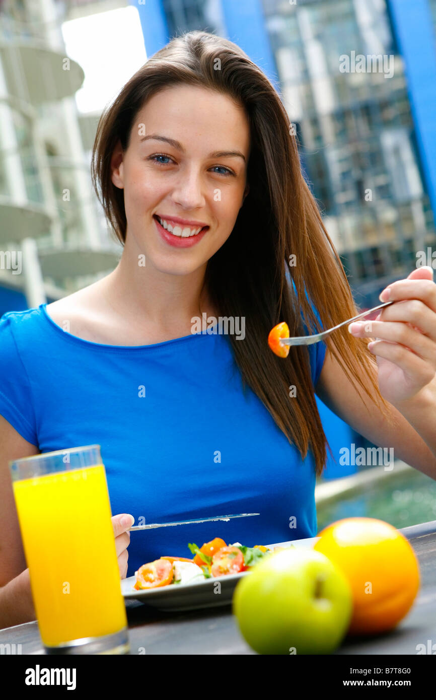 Young woman eating healthy food outside by water Stock Photo - Alamy