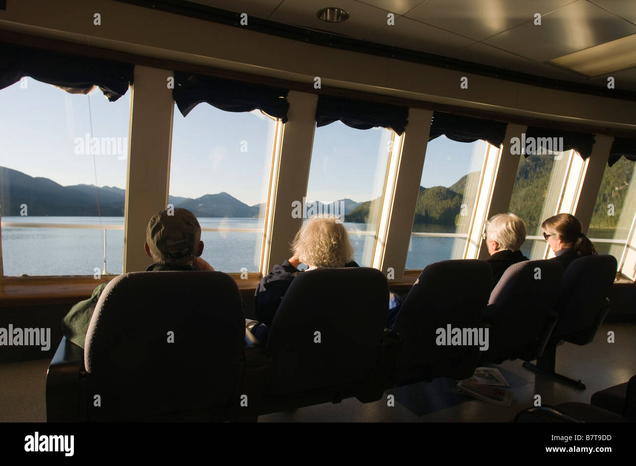 Tourists looking out the window of the observation deck of the Alaska ...