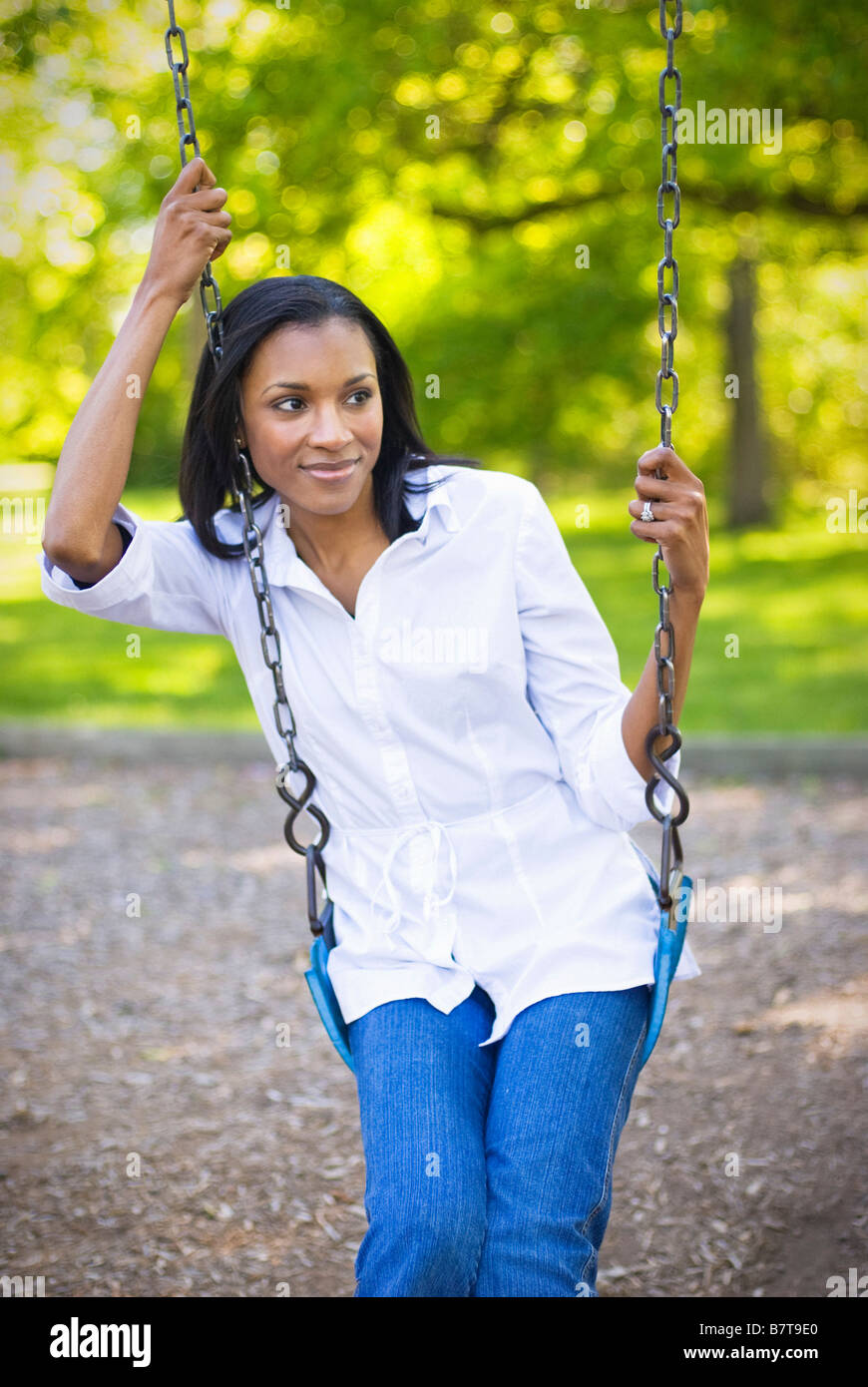 Woman sitting in swing Stock Photo - Alamy
