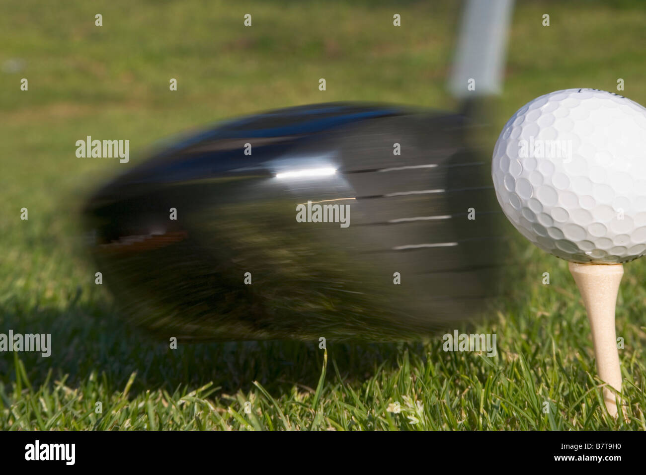 Golf ball on tee hit by driver Stock Photo - Alamy