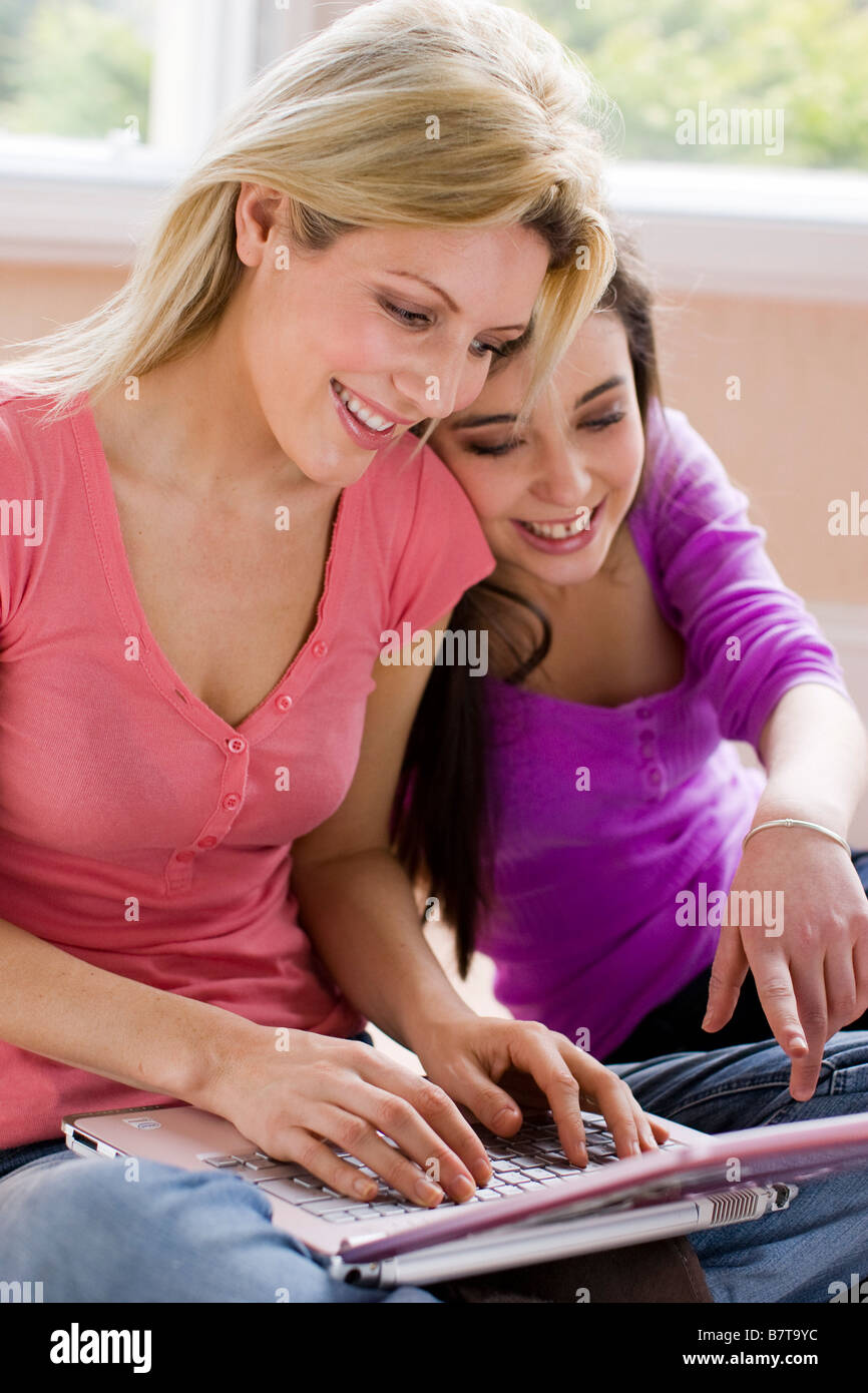 Two girls using computer online Stock Photo - Alamy