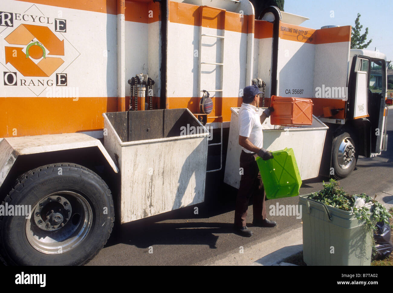 Waste management truck is filled by male worker in Orange, California ...