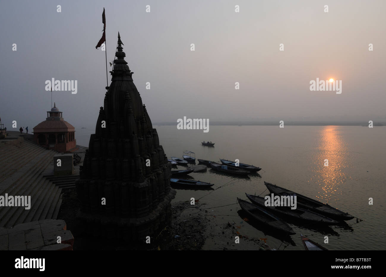 The sun rises over the River Ganges at the Scindia Ghat in Varanasi ...