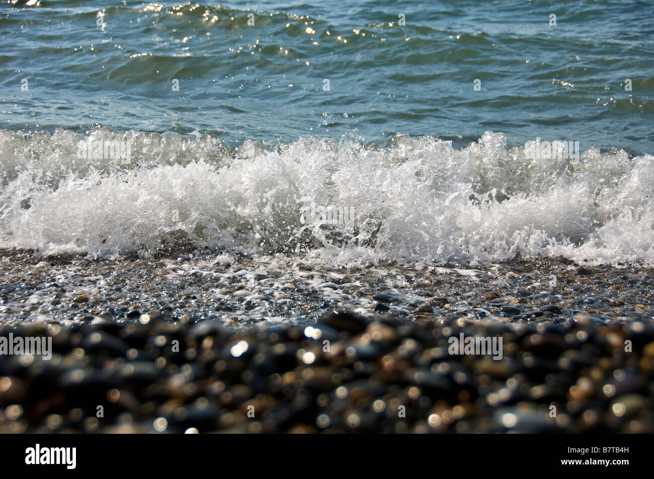 Waves crashing onto shingle beach Stock Photo - Alamy
