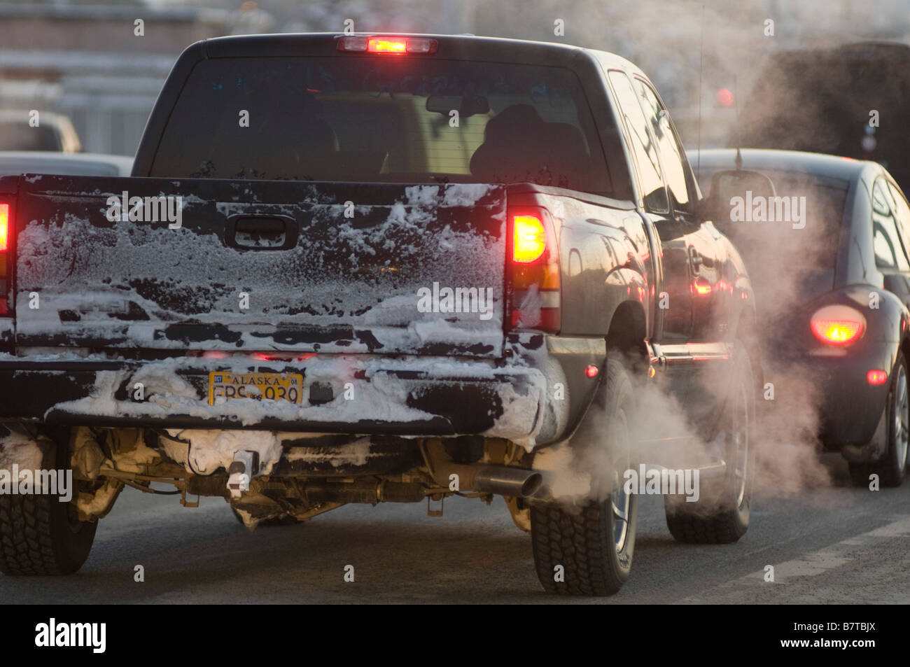Auto emissions- tailpipe exhaust from cars driving in town, waiting in ...