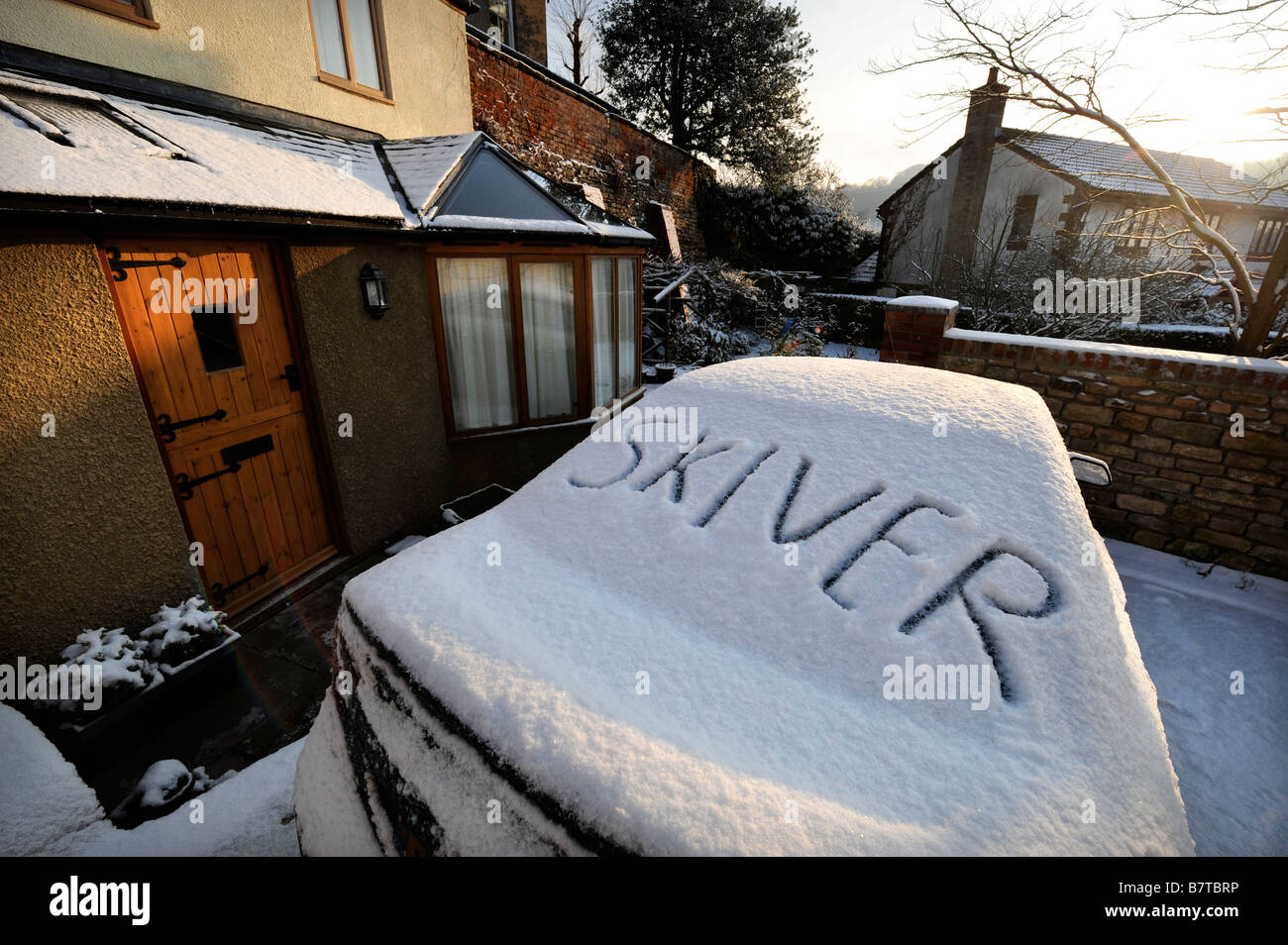CAR PARKED ON A DRIVEWAY WITH WORDS SKIVER WRITTEN IN SNOW SUGGESTING ...