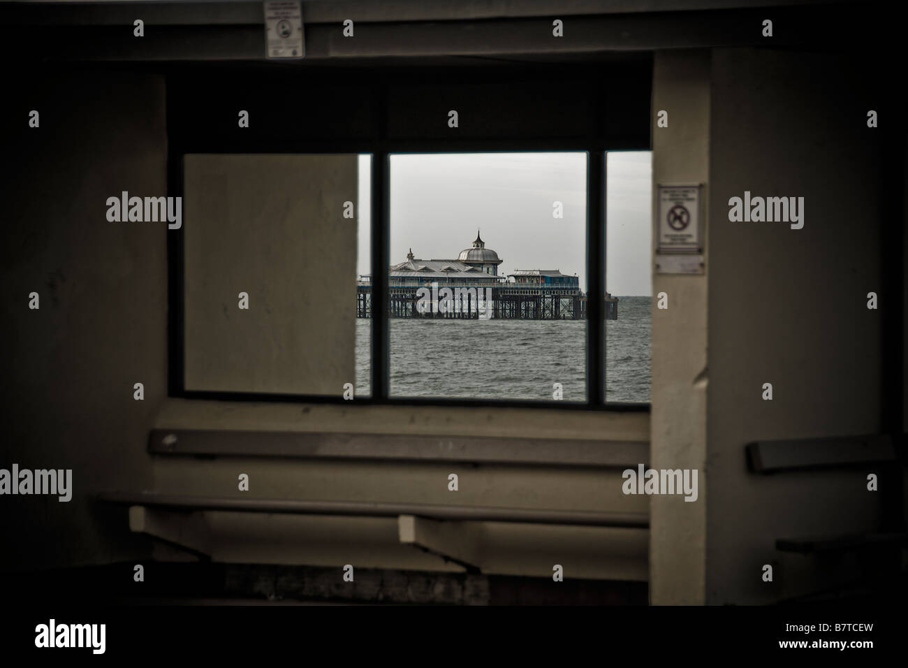 Monochrome view of Llandudno Pier through concrete weather shelter ...