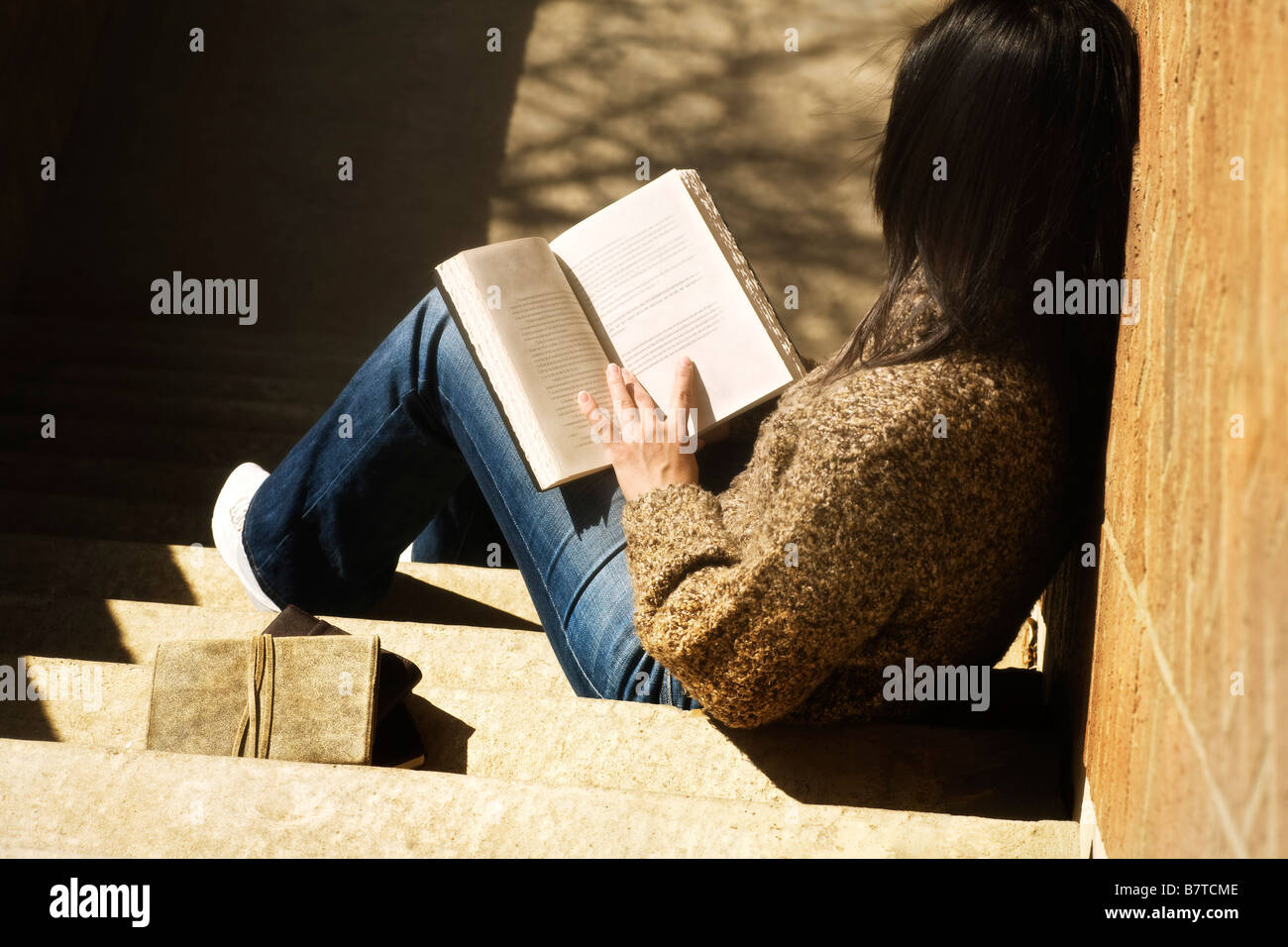 Woman reading on stairs Stock Photo - Alamy