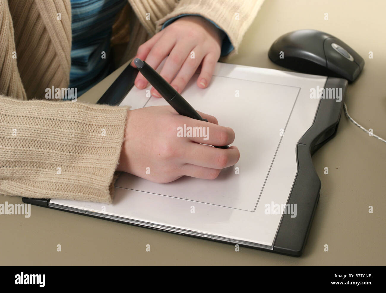 Female hands drawing with the stylus of a computer graphics tablet ...