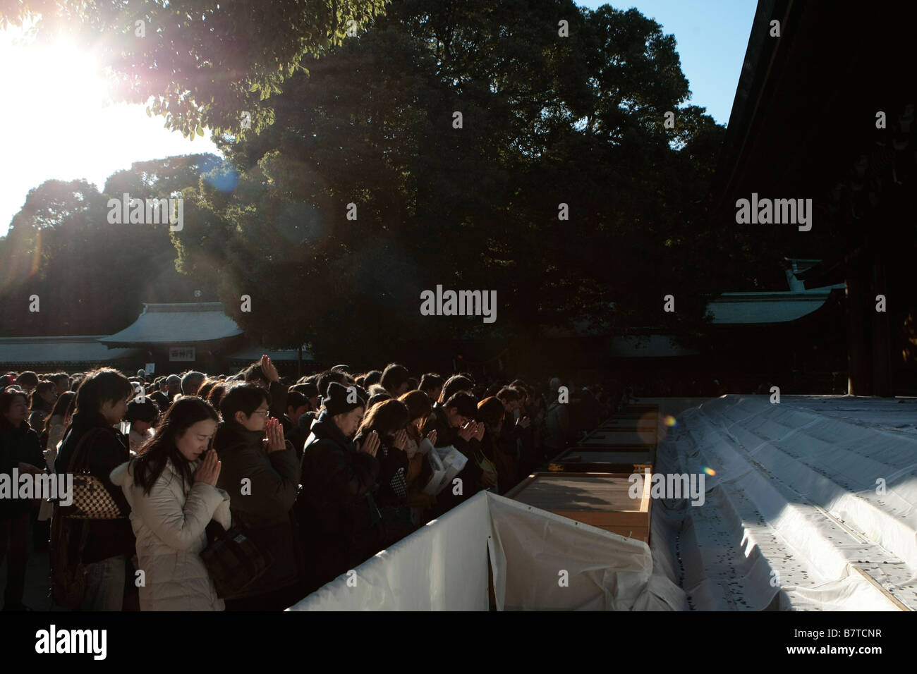 Japanese people pray at the Meiji Shinto shrine in Yoyogi Park in Tokyo ...