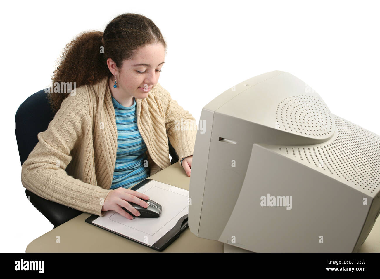 A teen girl doing computer graphics using a mouse and graphics tablet ...