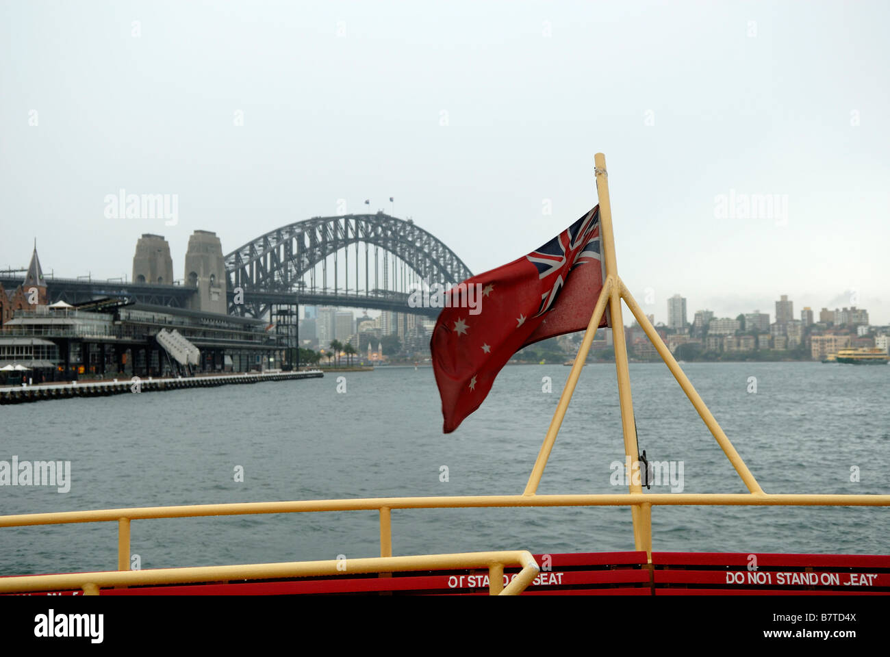 Red Ensign flying over top-deck seating and railing of Sydney Harbour ...