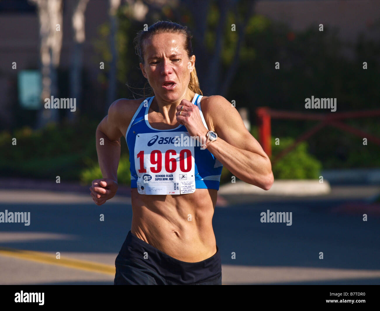 First female finisher strains as she nears the finish line at the ...