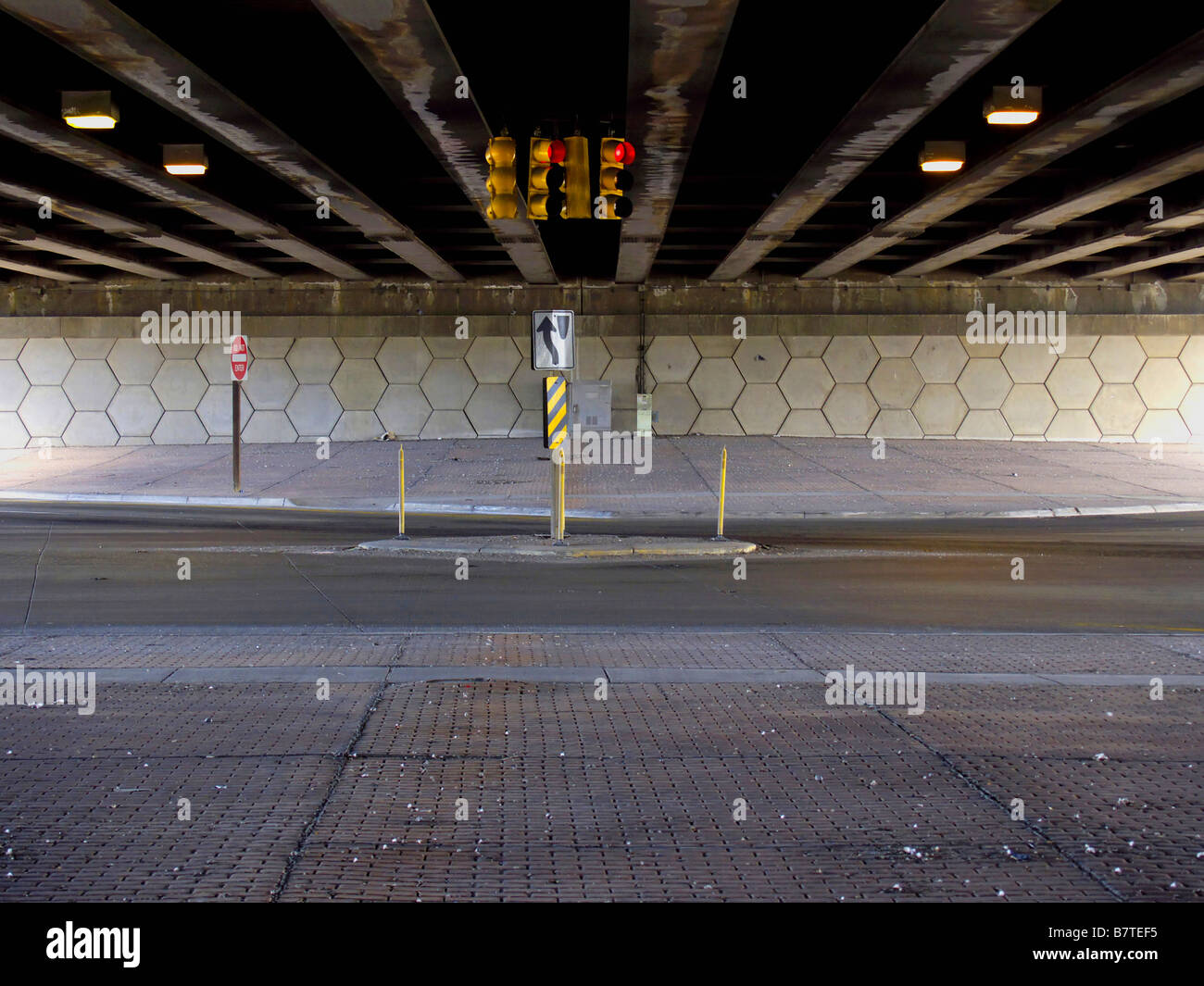 View under a freeway overpass showing traffic lights and street signs ...