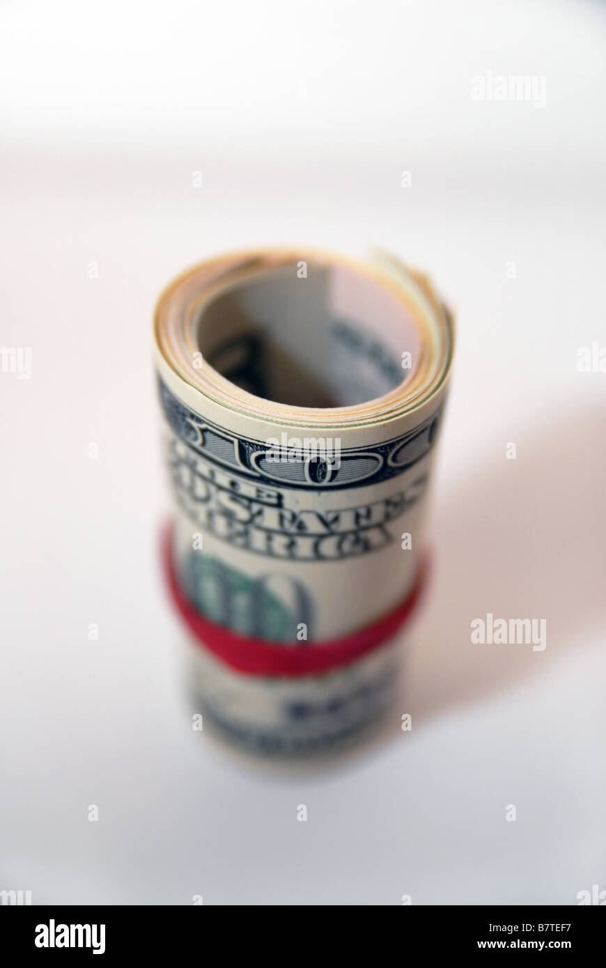 Dollar bank notes / currency / money rolled up in a bundle with an ...