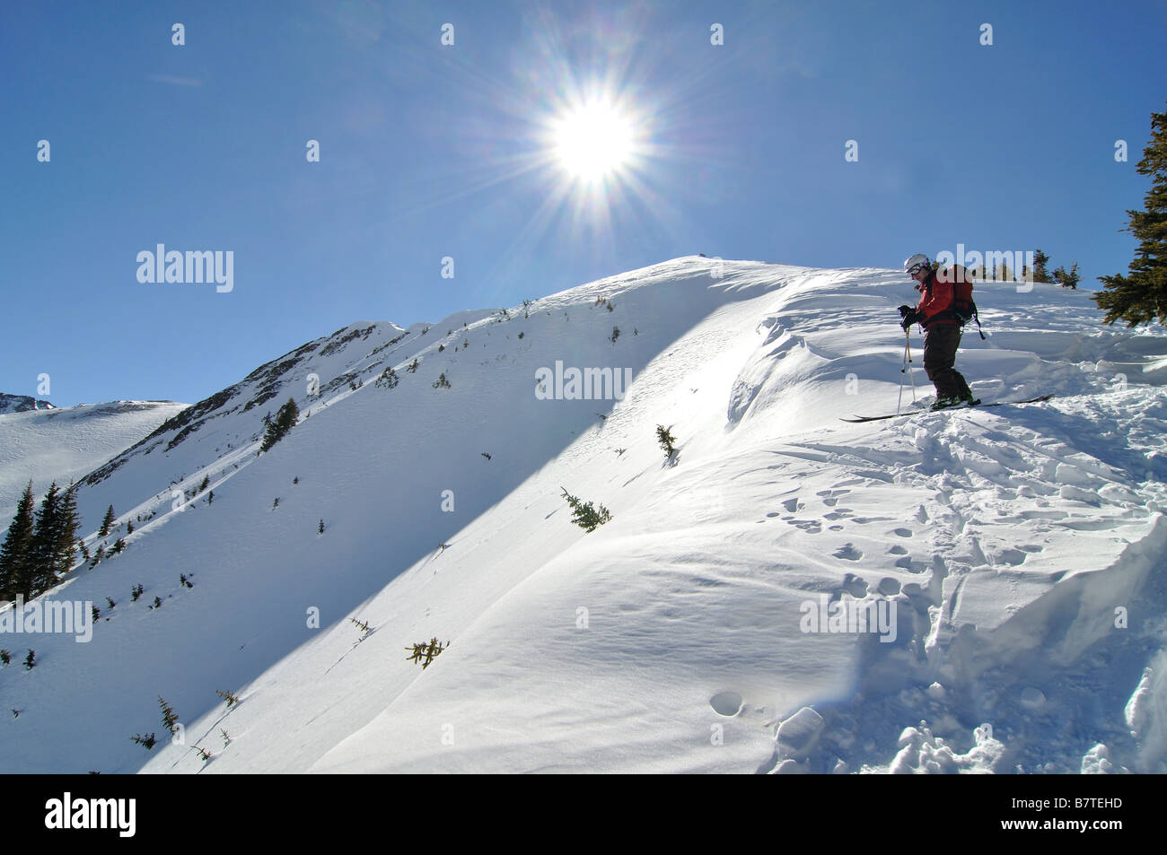a skier about to drop into a steep chute in the backcountry near ...