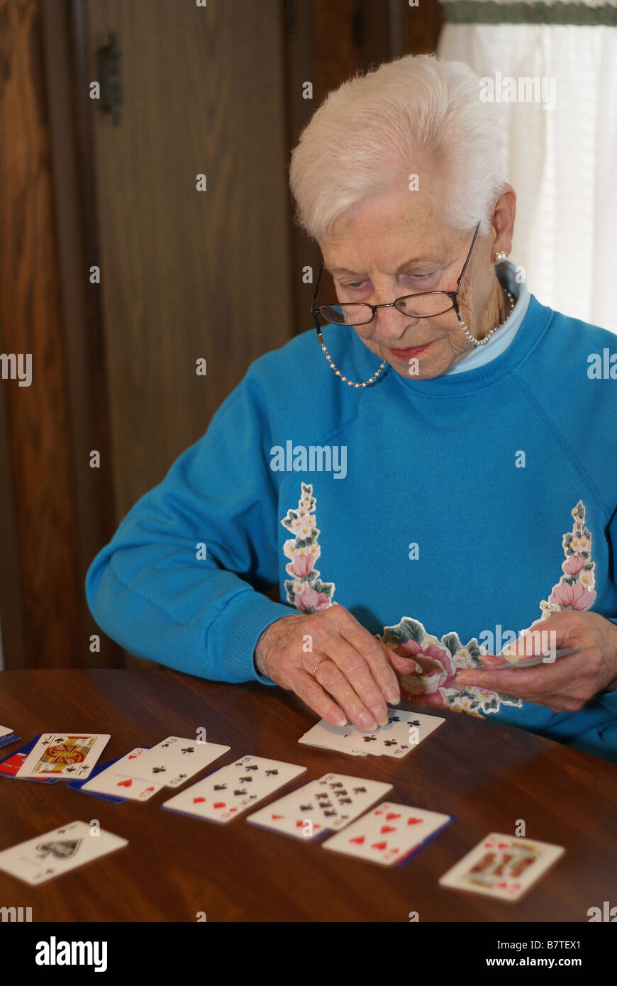 Woman playing solitaire card game hi-res stock photography and images ...