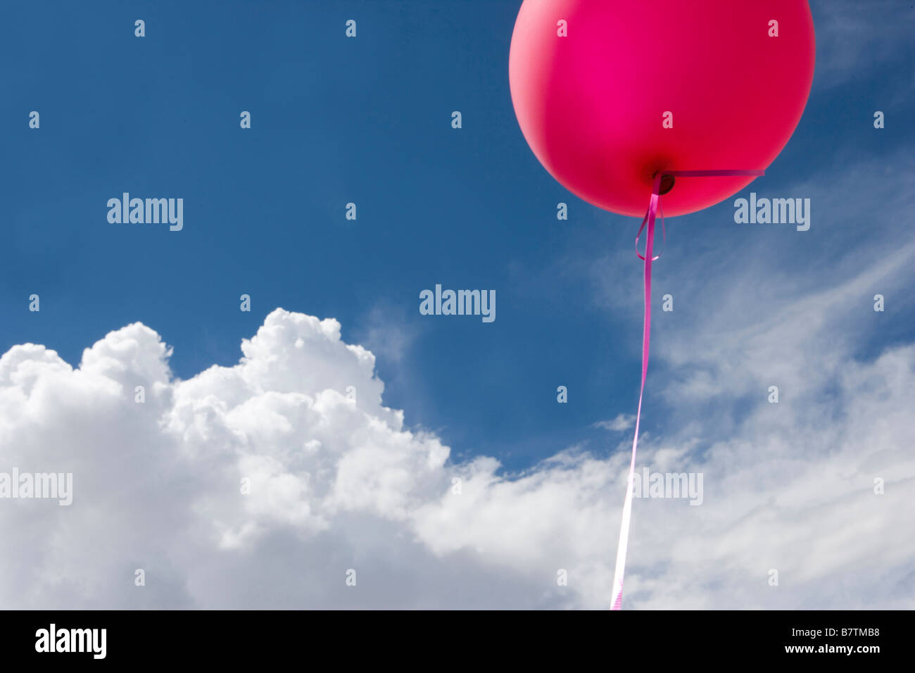 pink balloon floating up into the blue sky Stock Photo - Alamy
