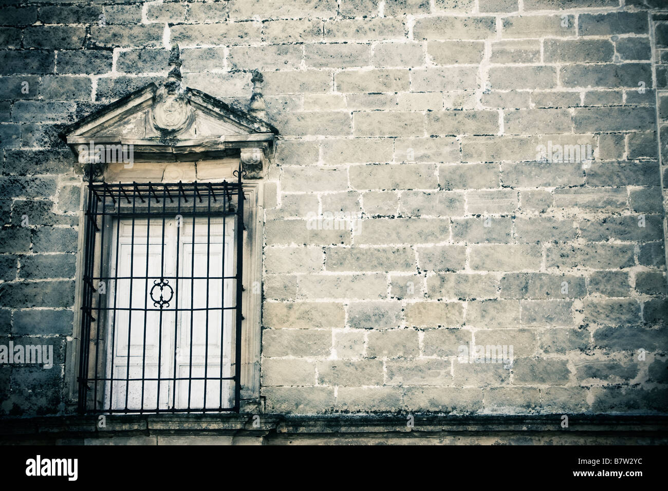 Old style window on creepy stonewall Stock Photo - Alamy