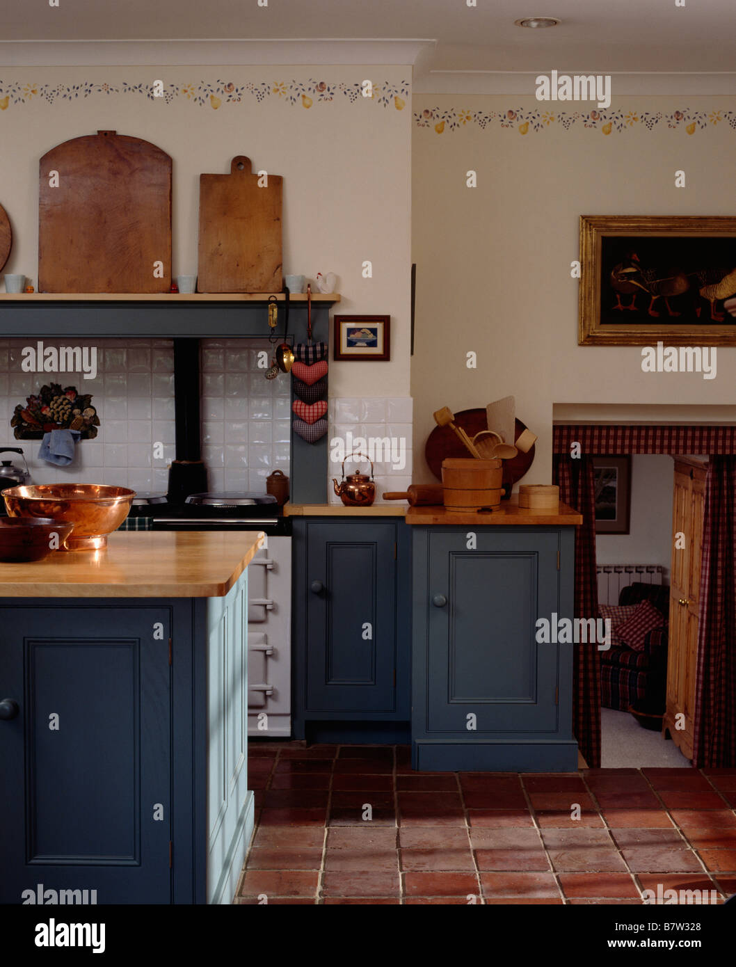 Stencilled border in country kitchen with wooden chopping boards on ...