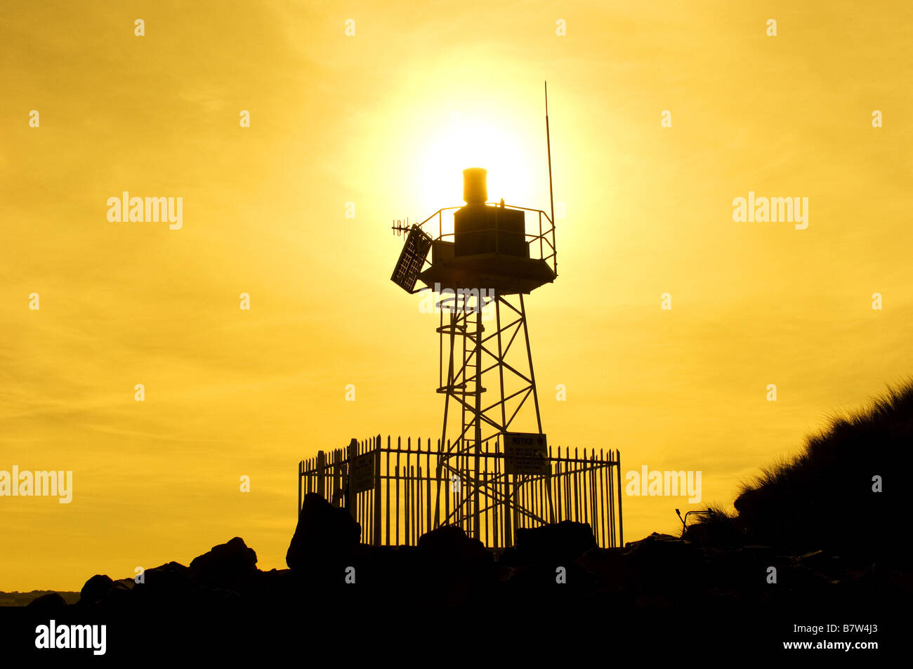 The sun silhouettes the navigation beacon at Crow Point, Barunton ...