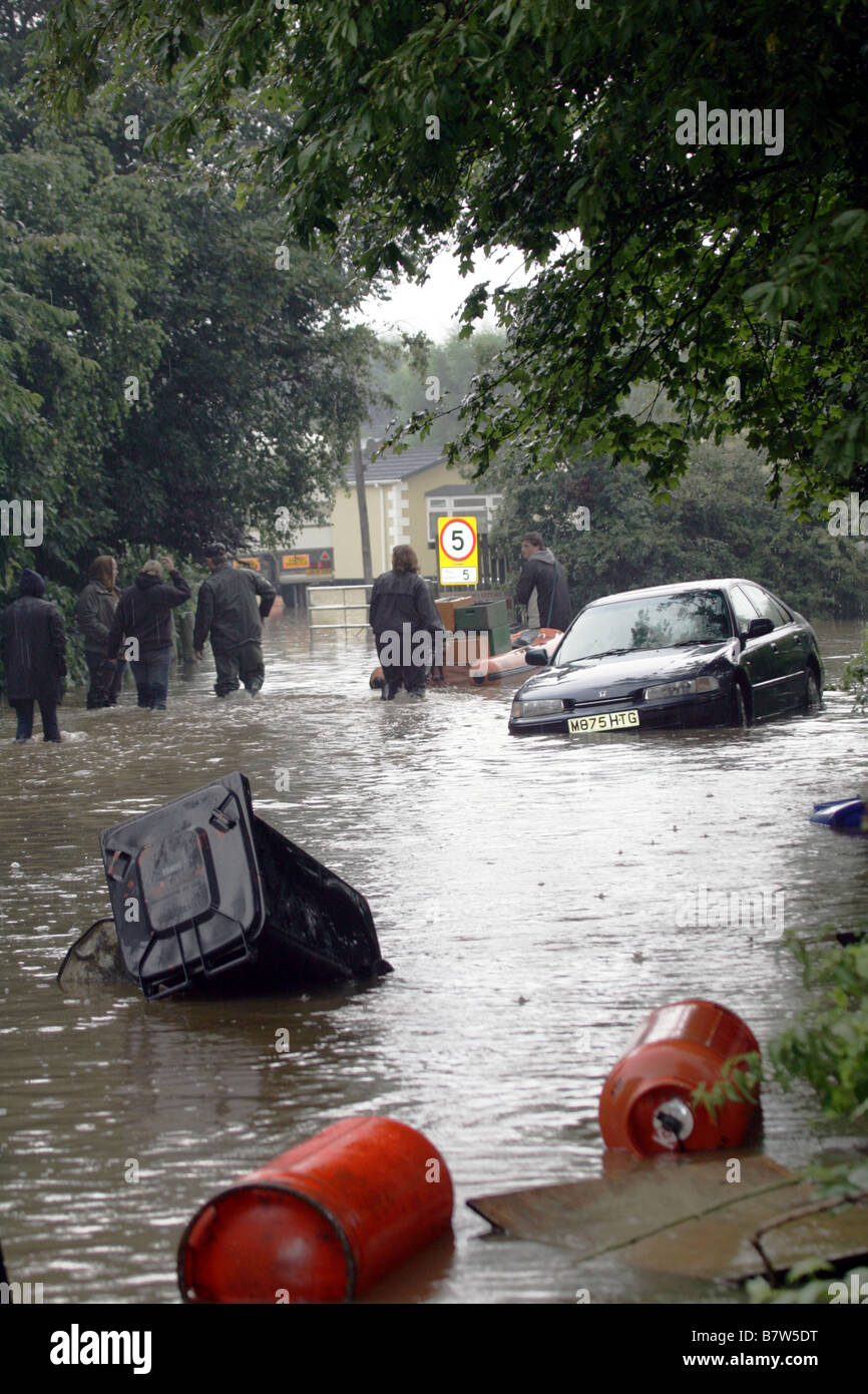 Residents walk down a flooded street near Over bridge in Gloucester to ...