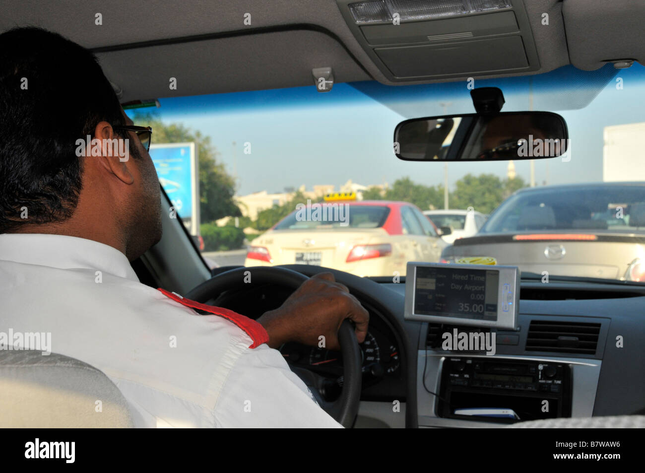 Interior close up back view of Dubai taxi cab worker driver hand on ...