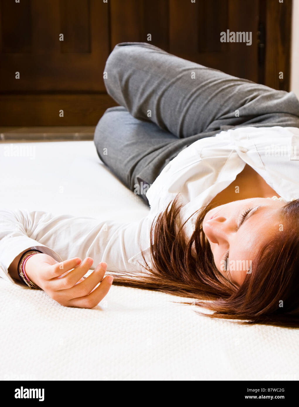 Young businesswoman laying on white sheets Stock Photo - Alamy