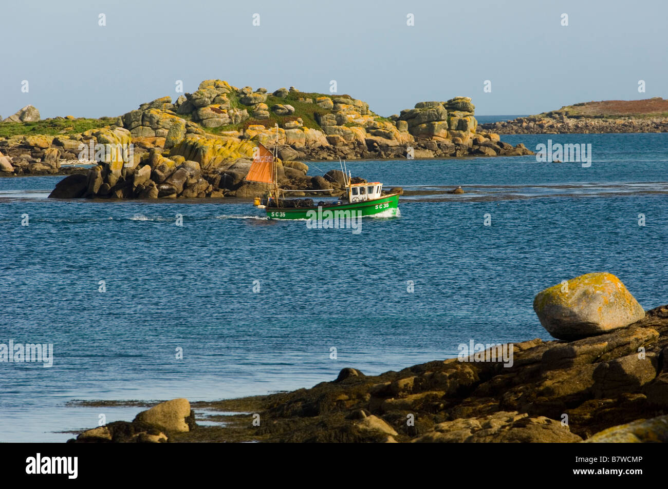 A green fishing boat returns to harbour off Tresco Isles of Scilly ...