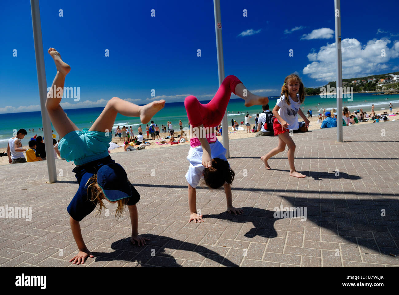 Three children (two 10 year olds, one 6 year old) doing handstands on ... Three children (two 10 year olds, one 6 year old) doing handstands on ...