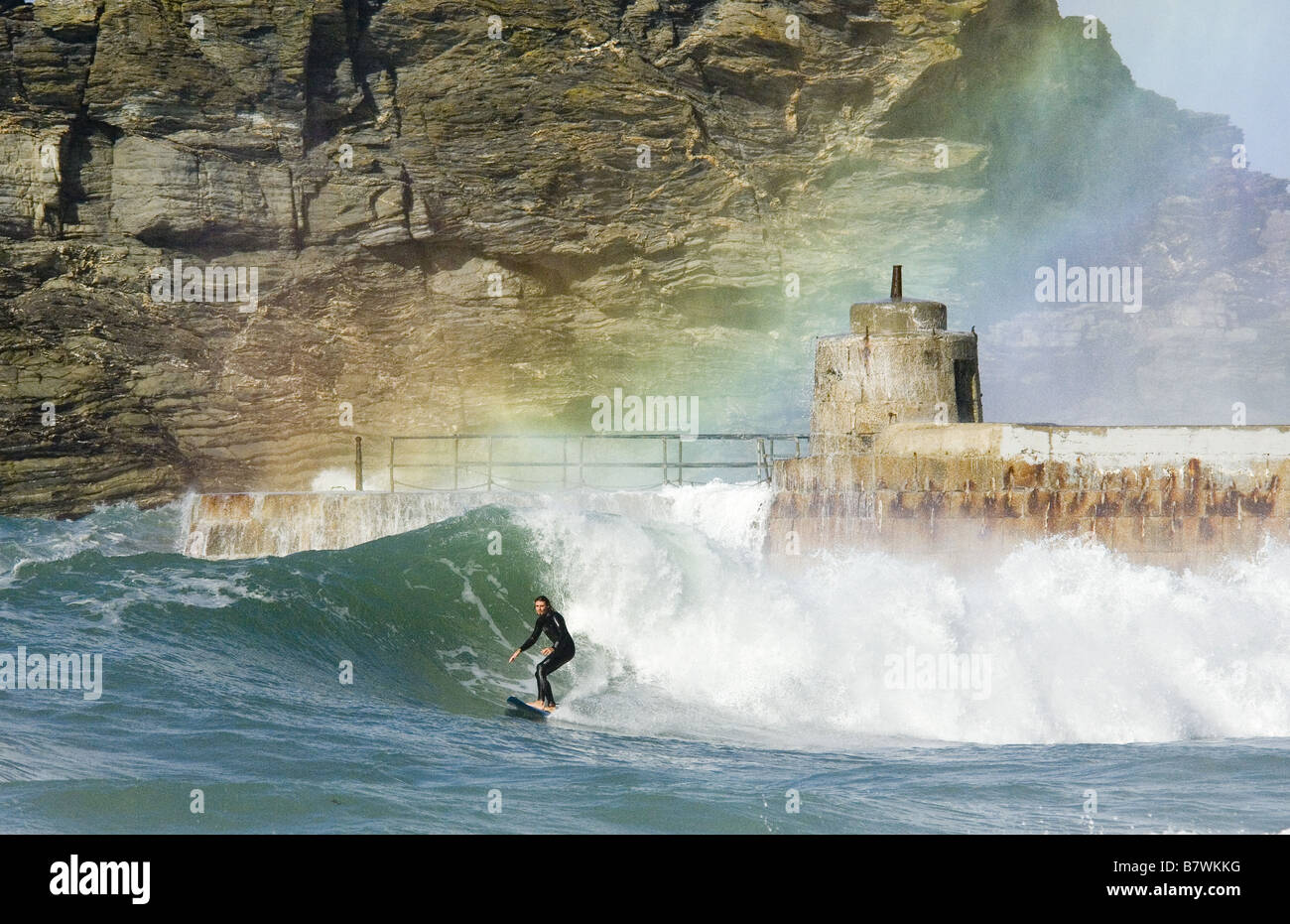Unknown surfer rides a rainbow wave, Portreath Harbour Wall in the ...