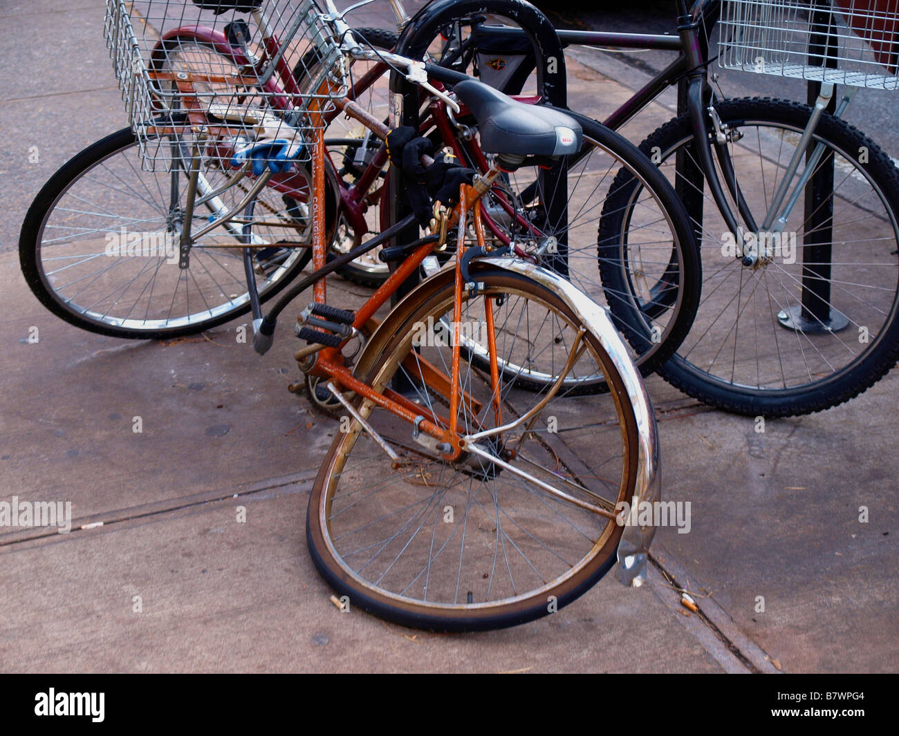 Bicycle with bent wheel chained to bicycle rack on sidewalk or pavement ... Bicycle with bent wheel chained to bicycle rack on sidewalk or pavement ...