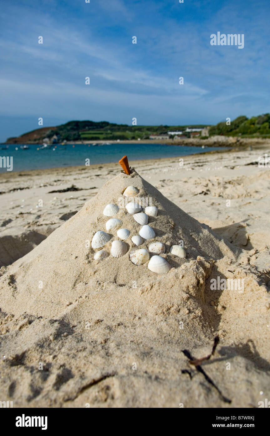 A sandcastle decorated with seashells on the beach by New Grimsby ...
