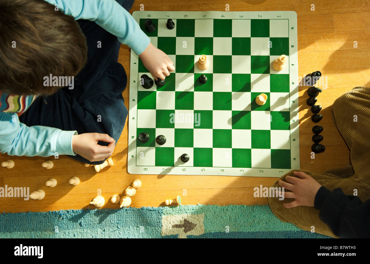 young boys playing chess on floor Stock Photo - Alamy