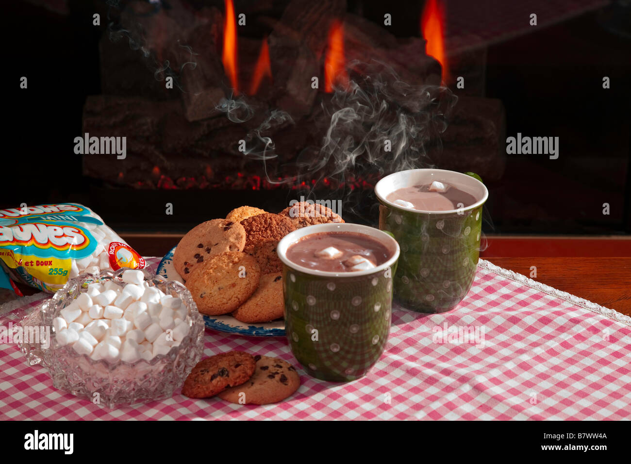 A Cup of hot steaming chocolate or cocoa with cookies by a fireplace ...