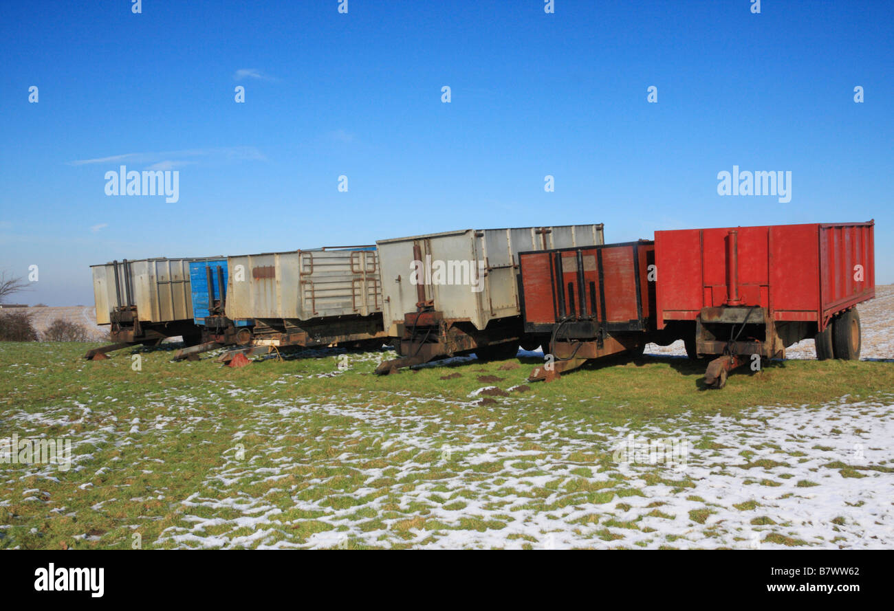 A group of farm trailers with a bright blue winter sky behind Stock ...
