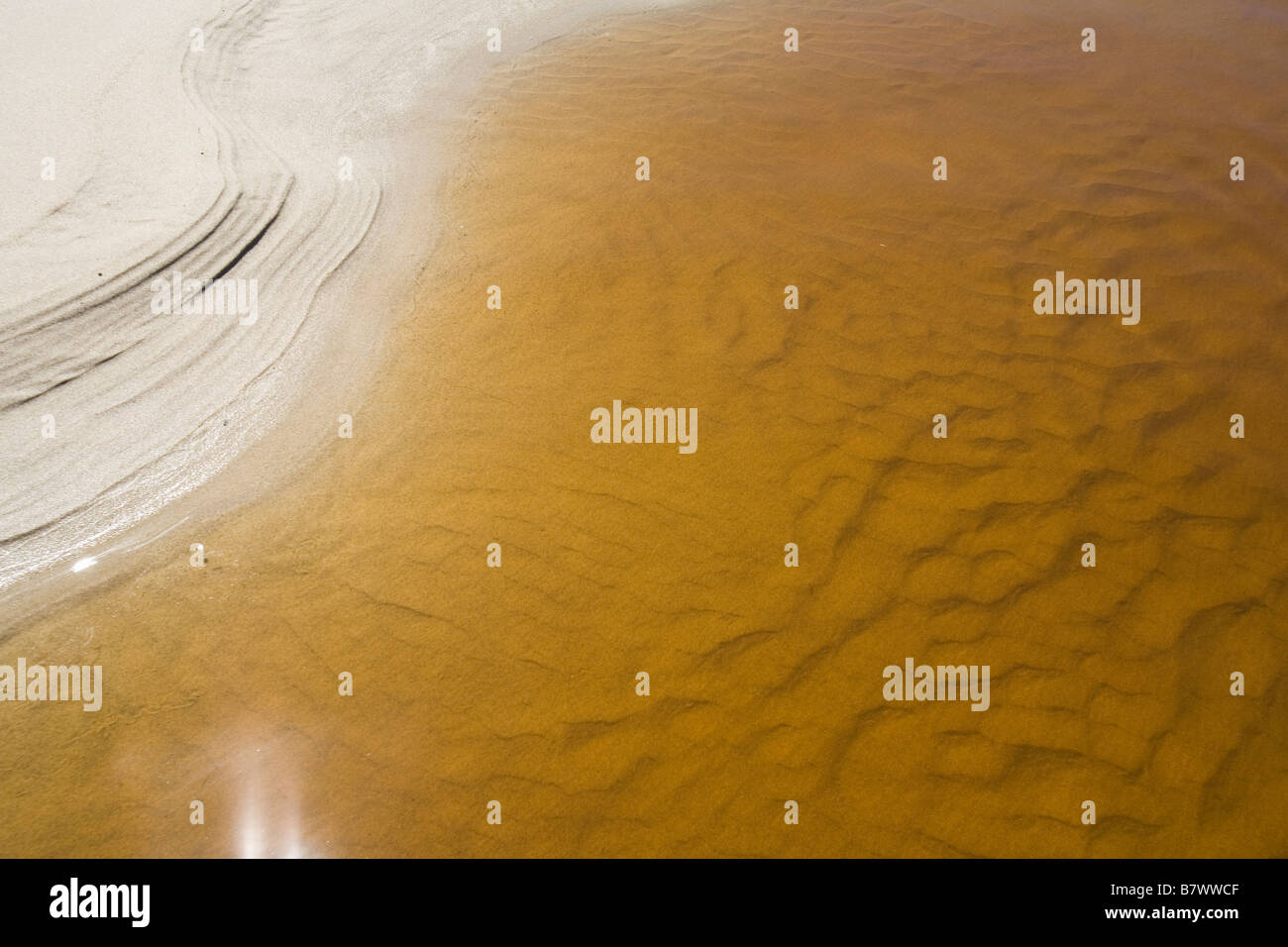 Detail of sand and water pattern at beach Stock Photo - Alamy