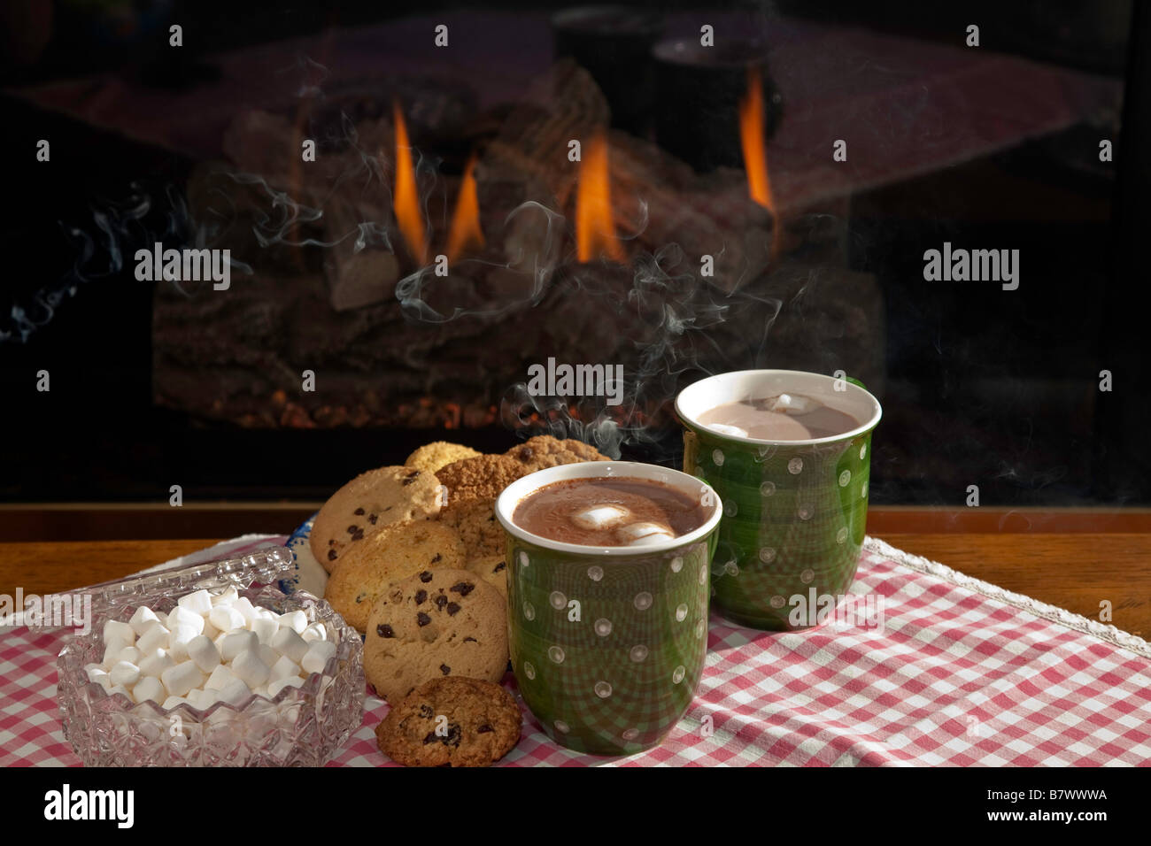 A Cup of hot steaming chocolate or cocoa with cookies by a fireplace ...