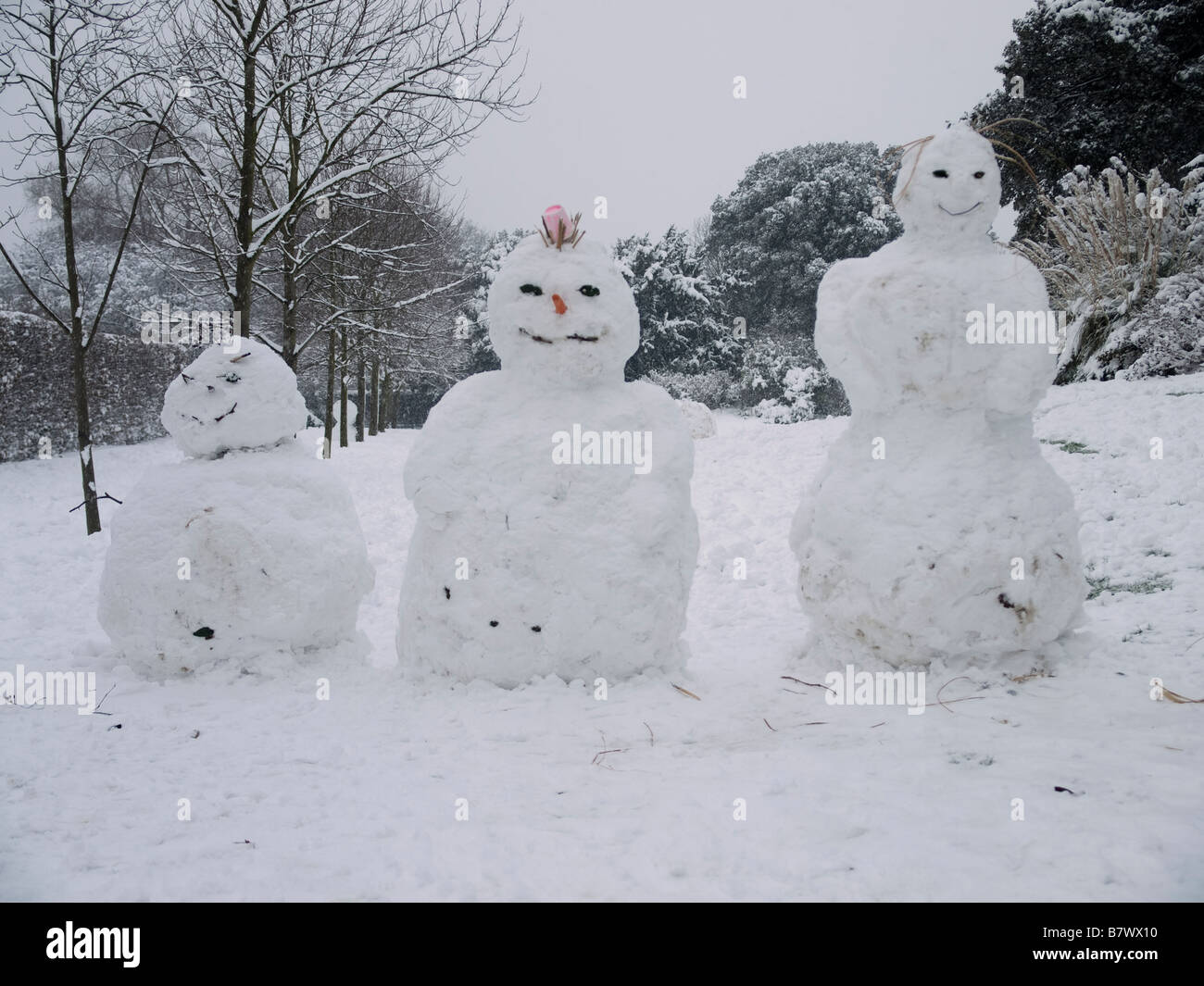 Three snowmen in a park Stock Photo - Alamy