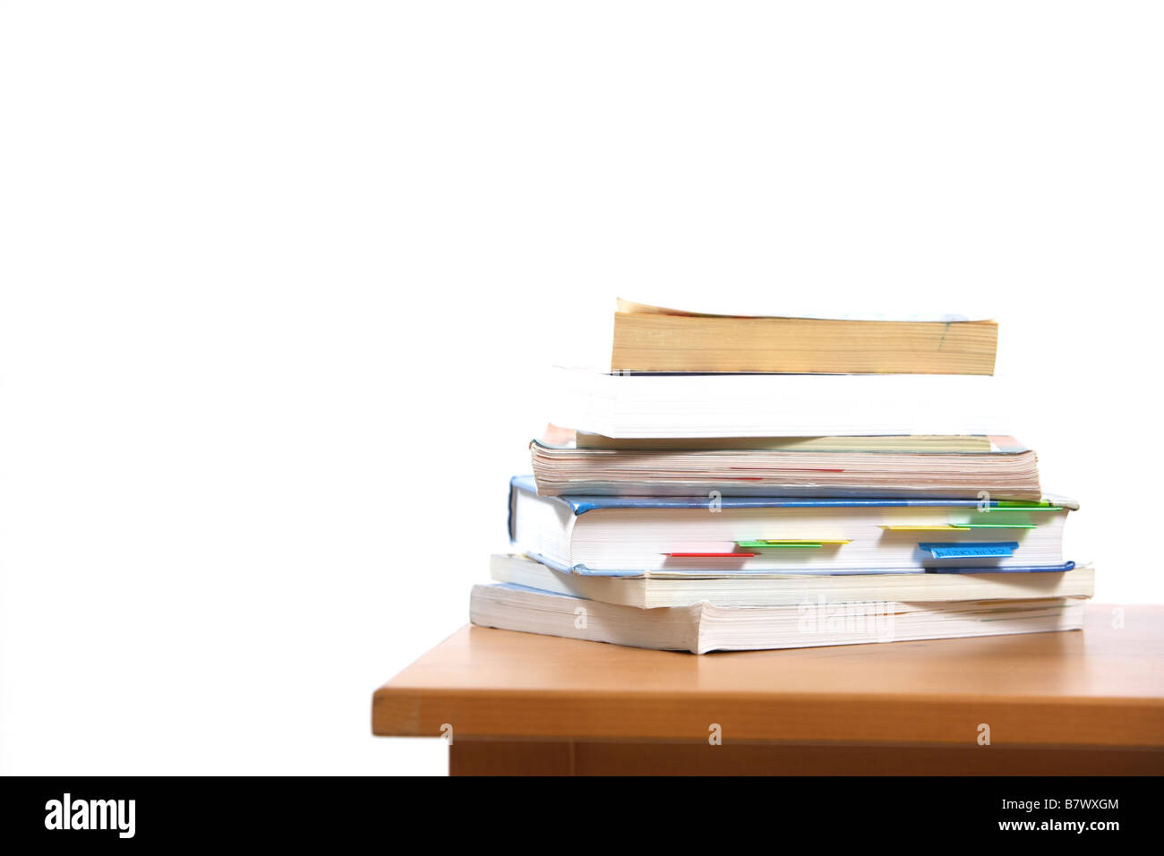 A stack of books sitting on the corner of a desk Stock Photo - Alamy